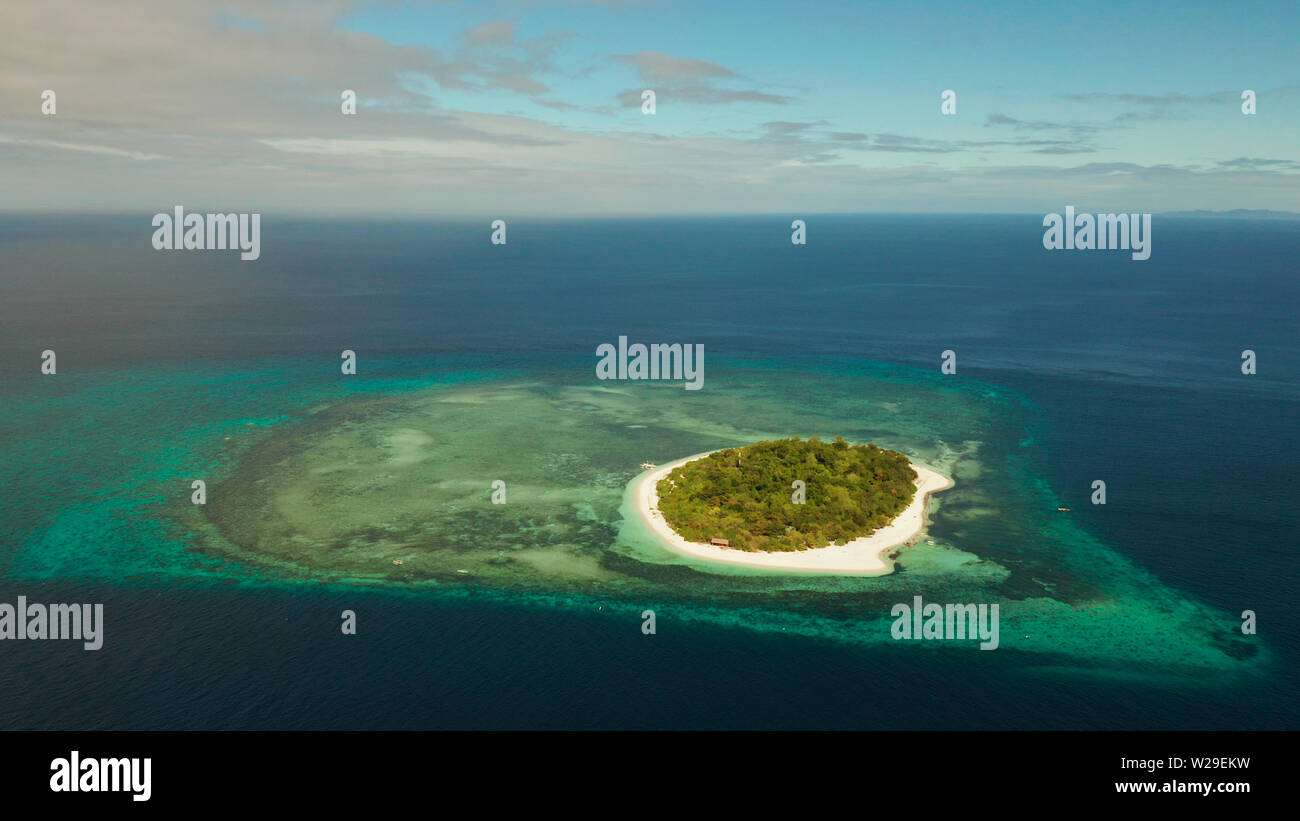 Tropical island and sandy beach surrounded by atoll and coral reef with ...