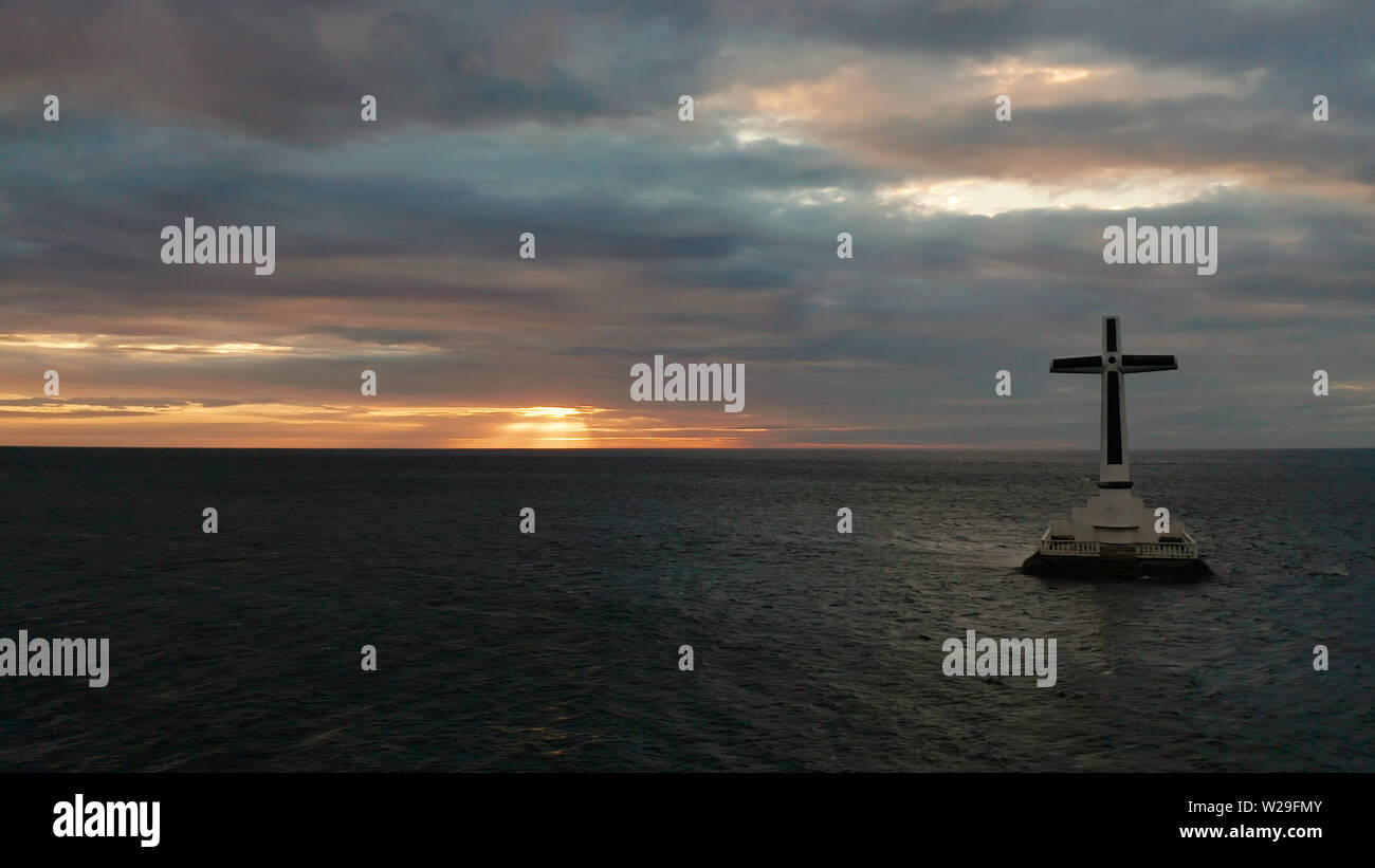 Catholic cross in sunken cemetery in the sea at sunset, aerial view ...