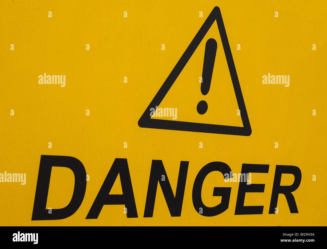 generic danger warning sign in black over yellow Stock Photo - Alamy