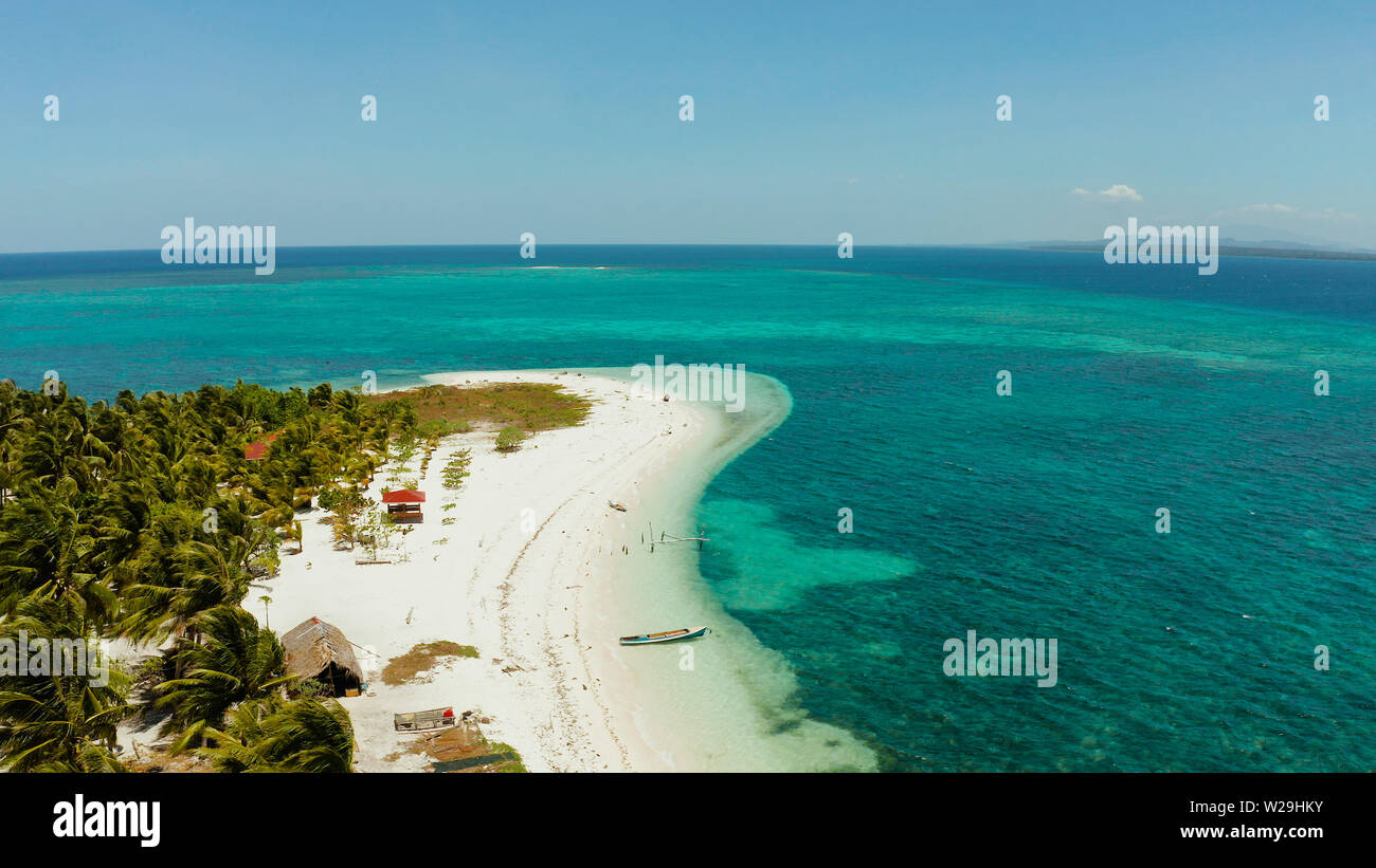 Small tropical island in the blue sea with a coral reef and the beach ...