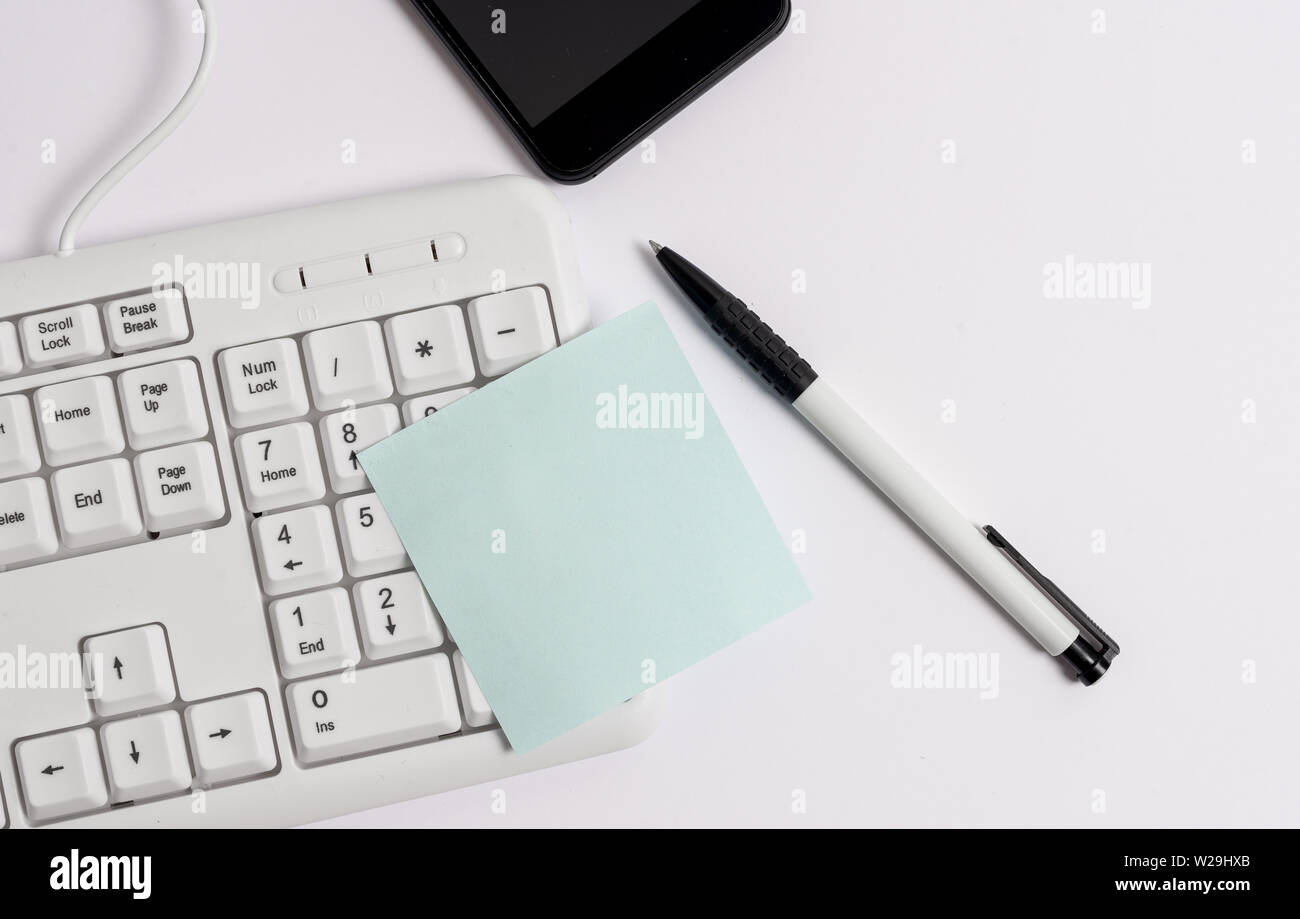 White pc keyboard with empty note paper above white background Stock ...