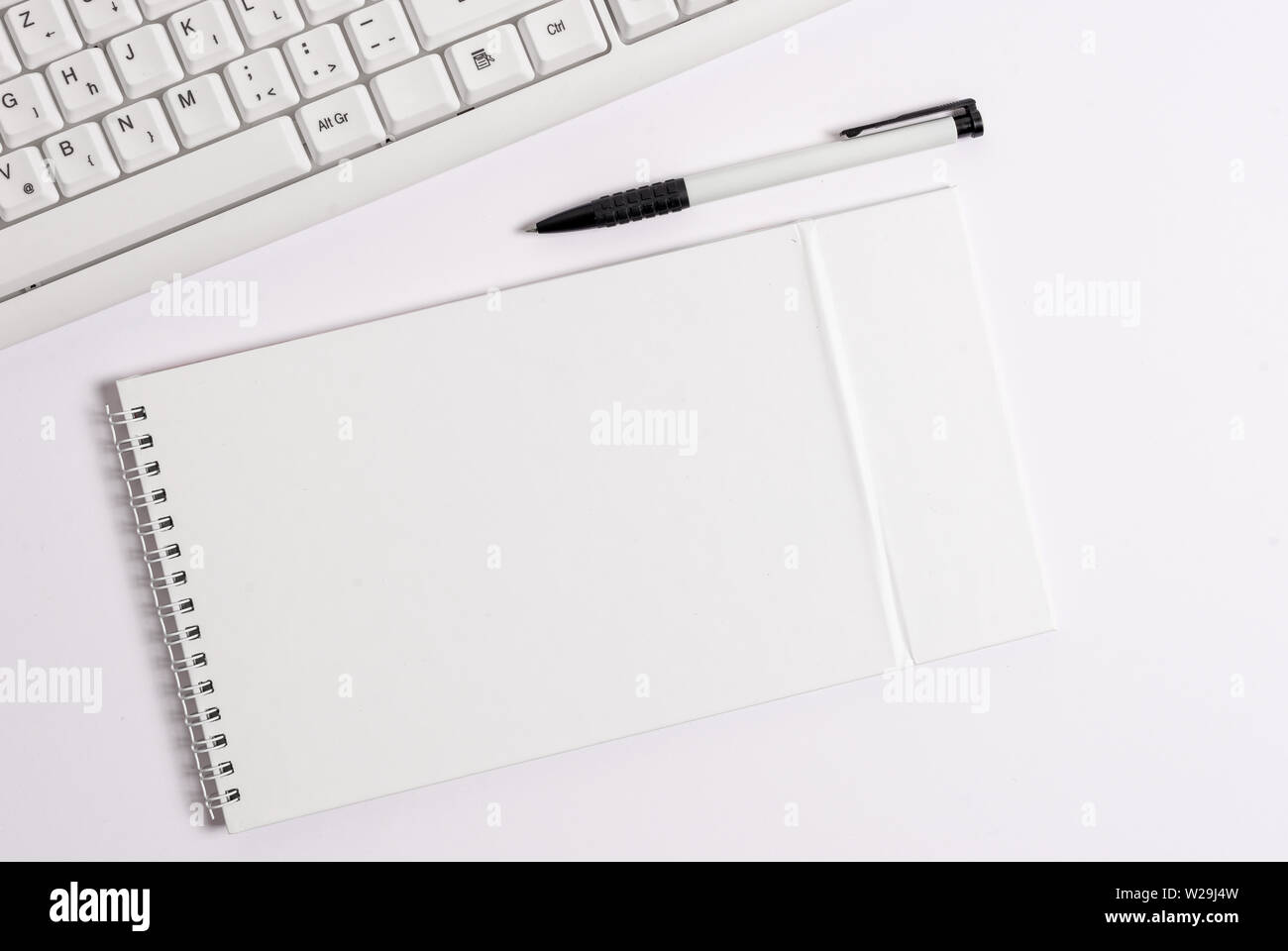 White pc keyboard with empty note paper above white background Stock ...
