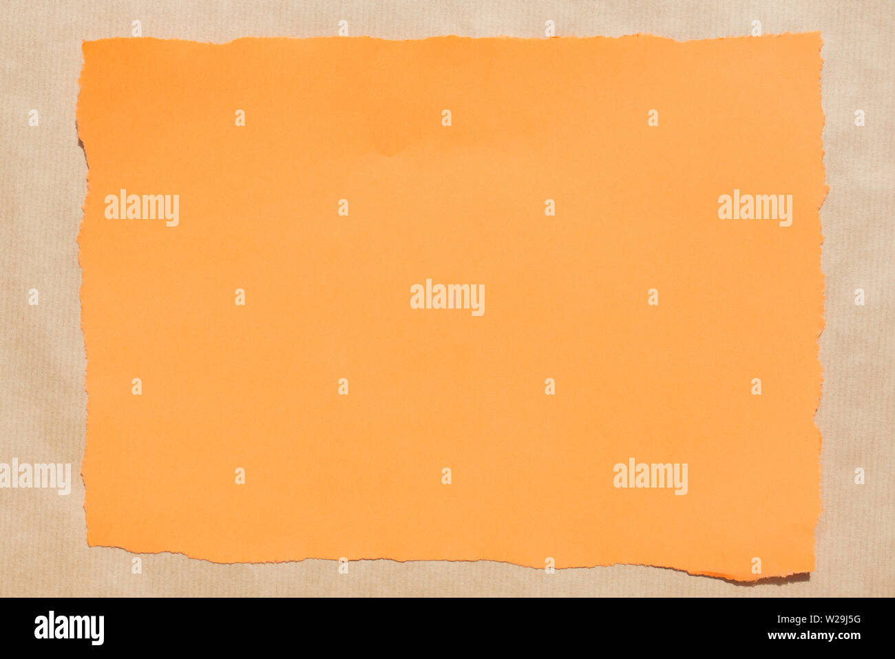 orange color piece of torn paper on recycled paper background texture ...