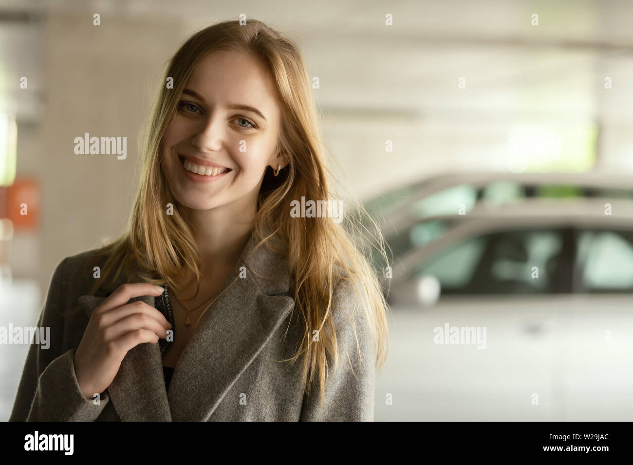 happy young woman at underground parking smiling Stock Photo - Alamy