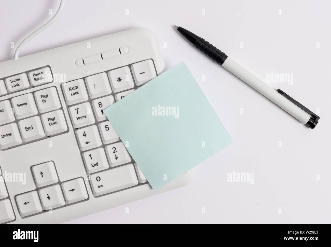 White pc keyboard with empty note paper above white background Stock ...