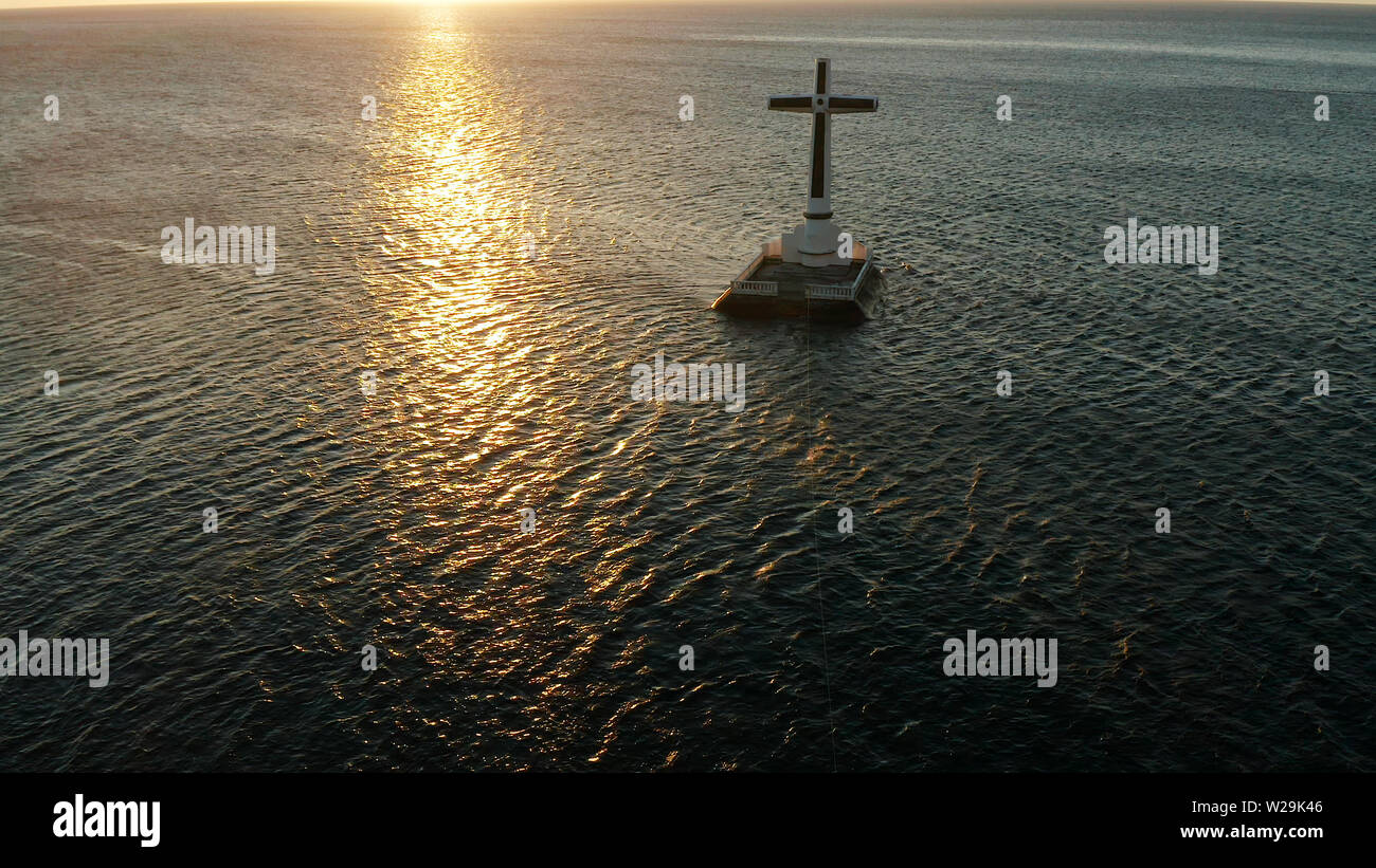 Catholic cross in sunken cemetery in the sea at sunset, aerial view ...