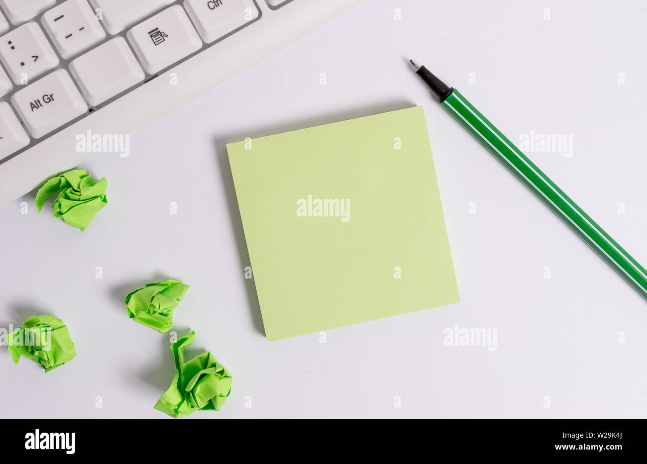 Square empty green note paper with pencil on the white background and ...