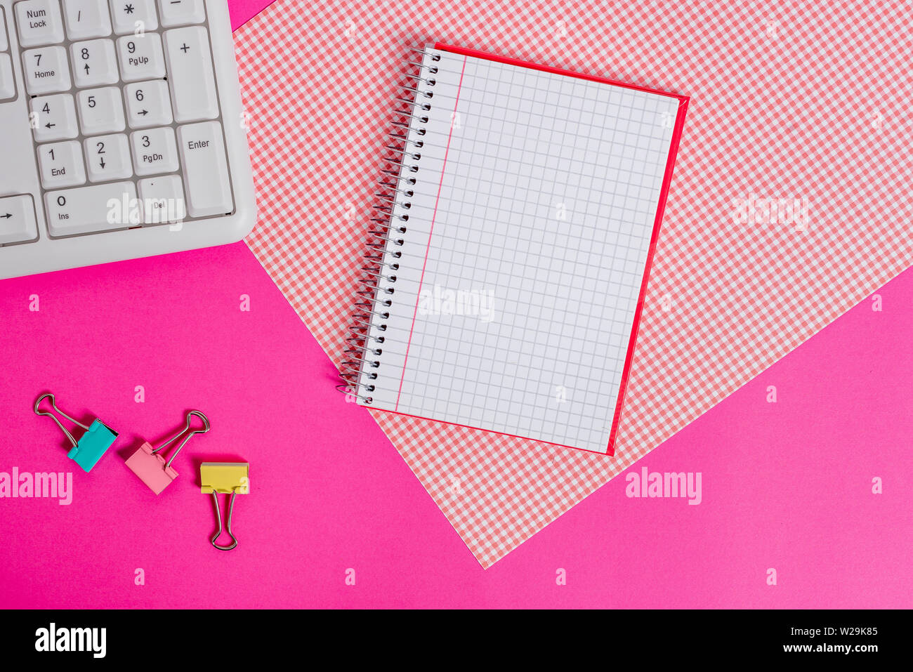 Writing equipments and computer stuffs placed above colored plain table ...