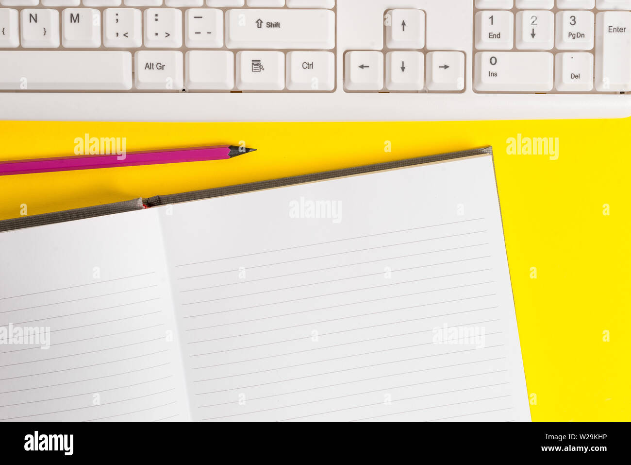 Copy space on notebook above yellow background with pc keyboard and ...