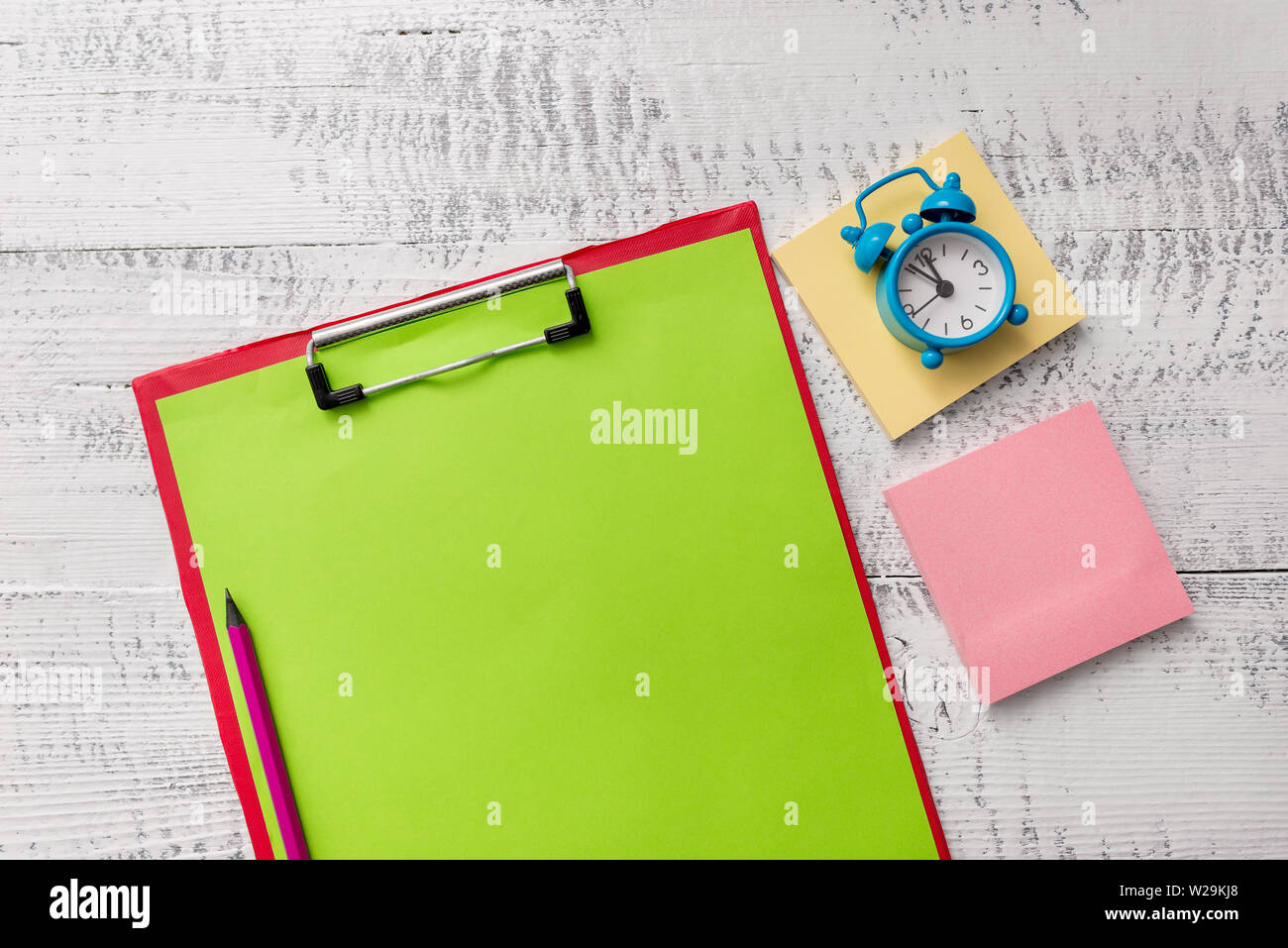 Metal clipboard sheets marker alarm clock notes pad wooden background ...