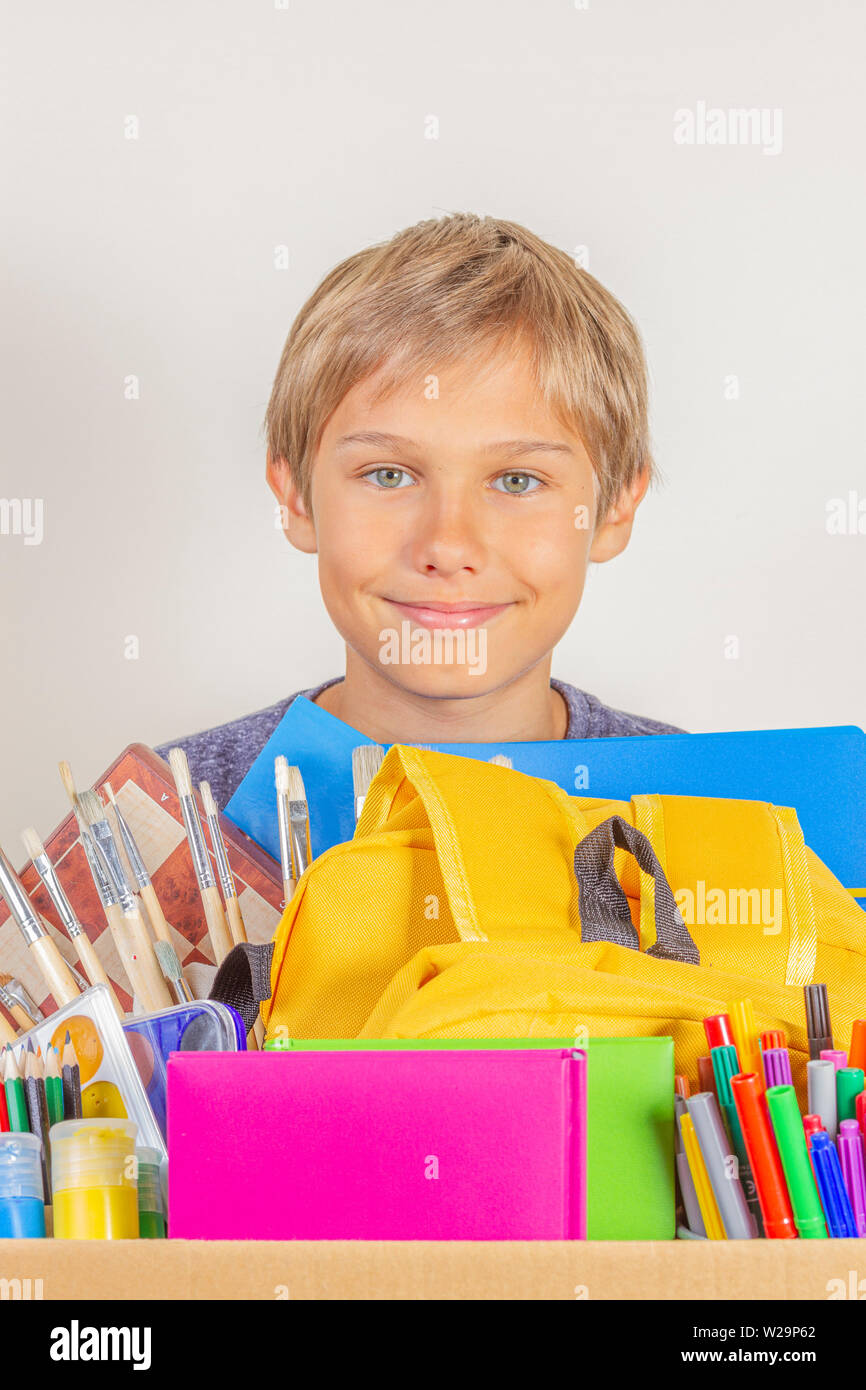 Donation concept. Kid holding donate box with books, pencils and school ...