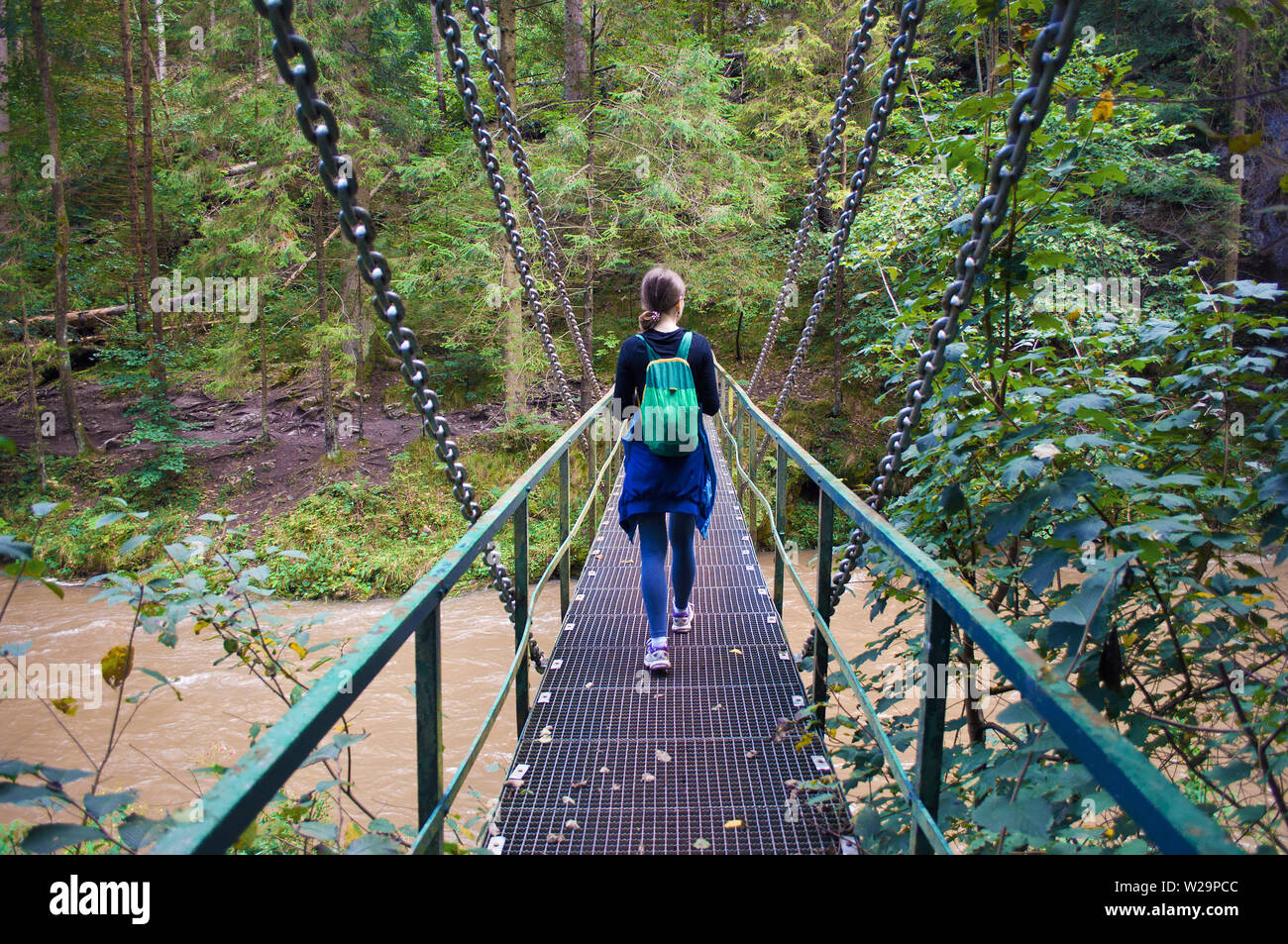 Back of one young woman on a metal bridge above Hornad river, Slovensky ...