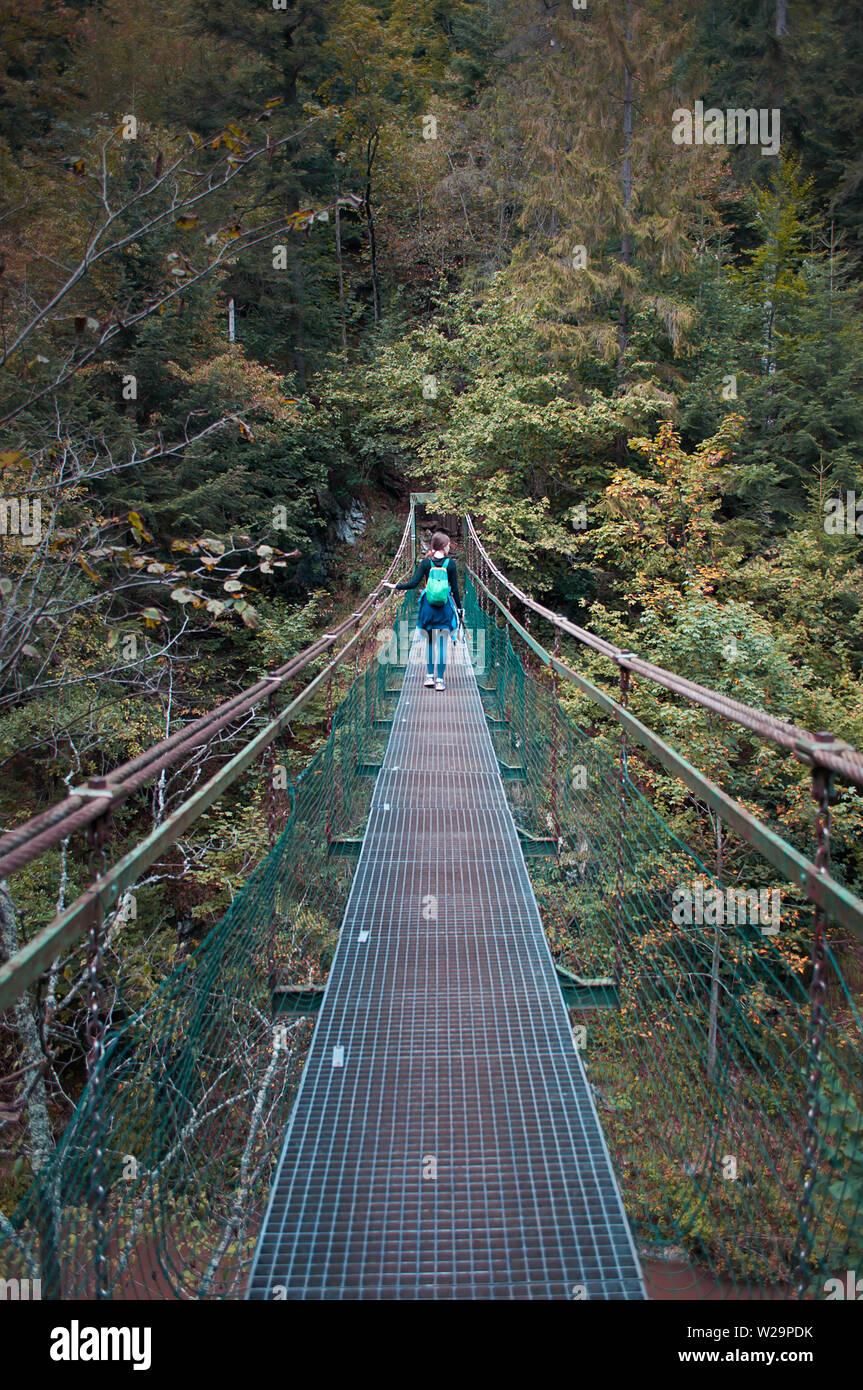 Back of one young woman on Klastorna lavka rope foot-bridge above ...
