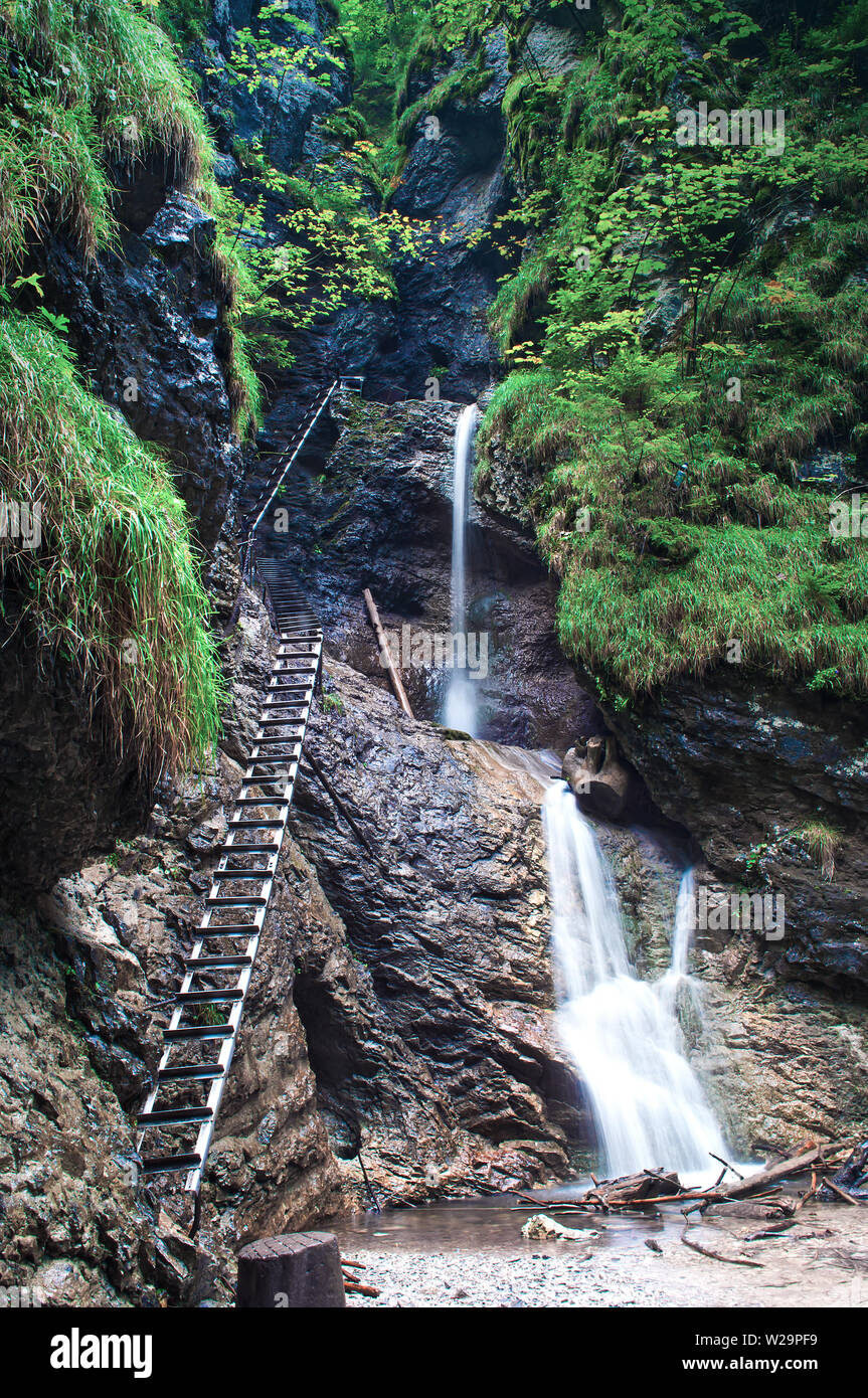 View of Misove waterfall, long metal ladder. Water falling down the ...
