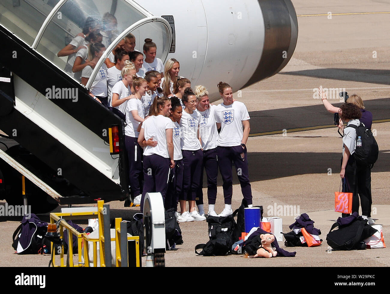 The England Women's team pose for a photograph by their plane after ...
