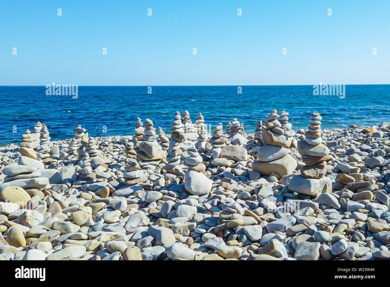 Seascape with views of pebble beach and stone pyramids Stock Photo - Alamy