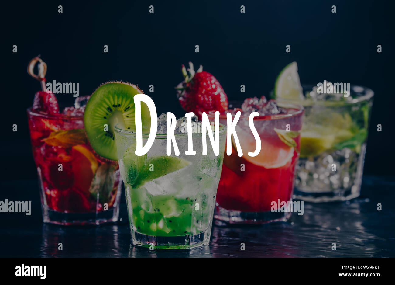 Four colorful tasty alcoholic cocktails in a row at the bar stand ...