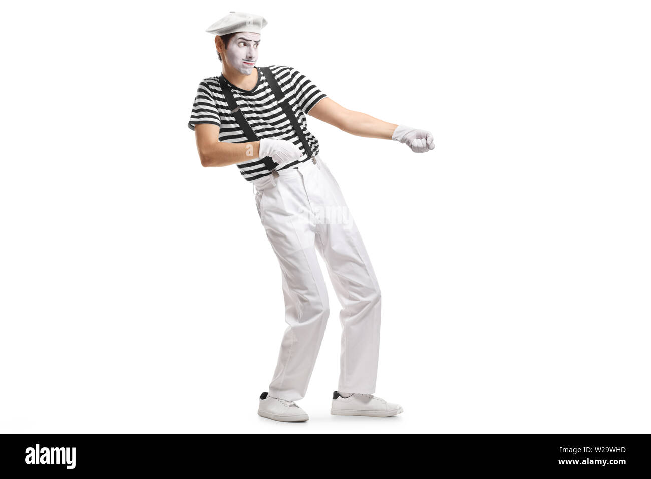 Full length shot of a mime pulling an imaginary rope isolated on white ...