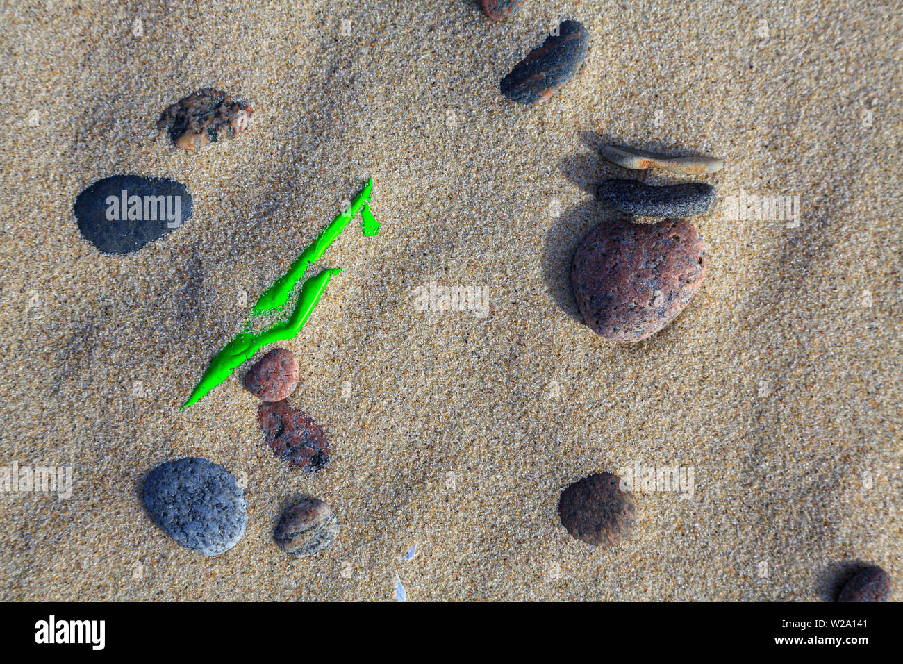 Environmental pollution - remain of a green balloon lying on the beach ...
