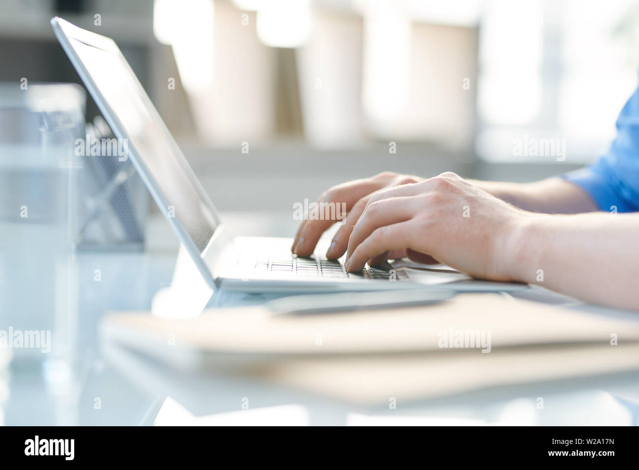 Hands of student or young entrepreneur touching keys of laptop keypad ...