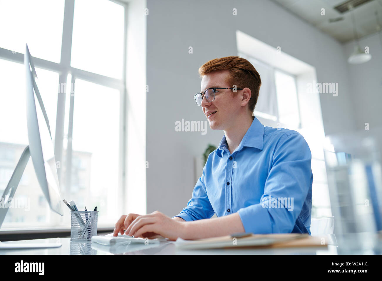 Happy guy in formalwear looking at computer screen Stock Photo - Alamy