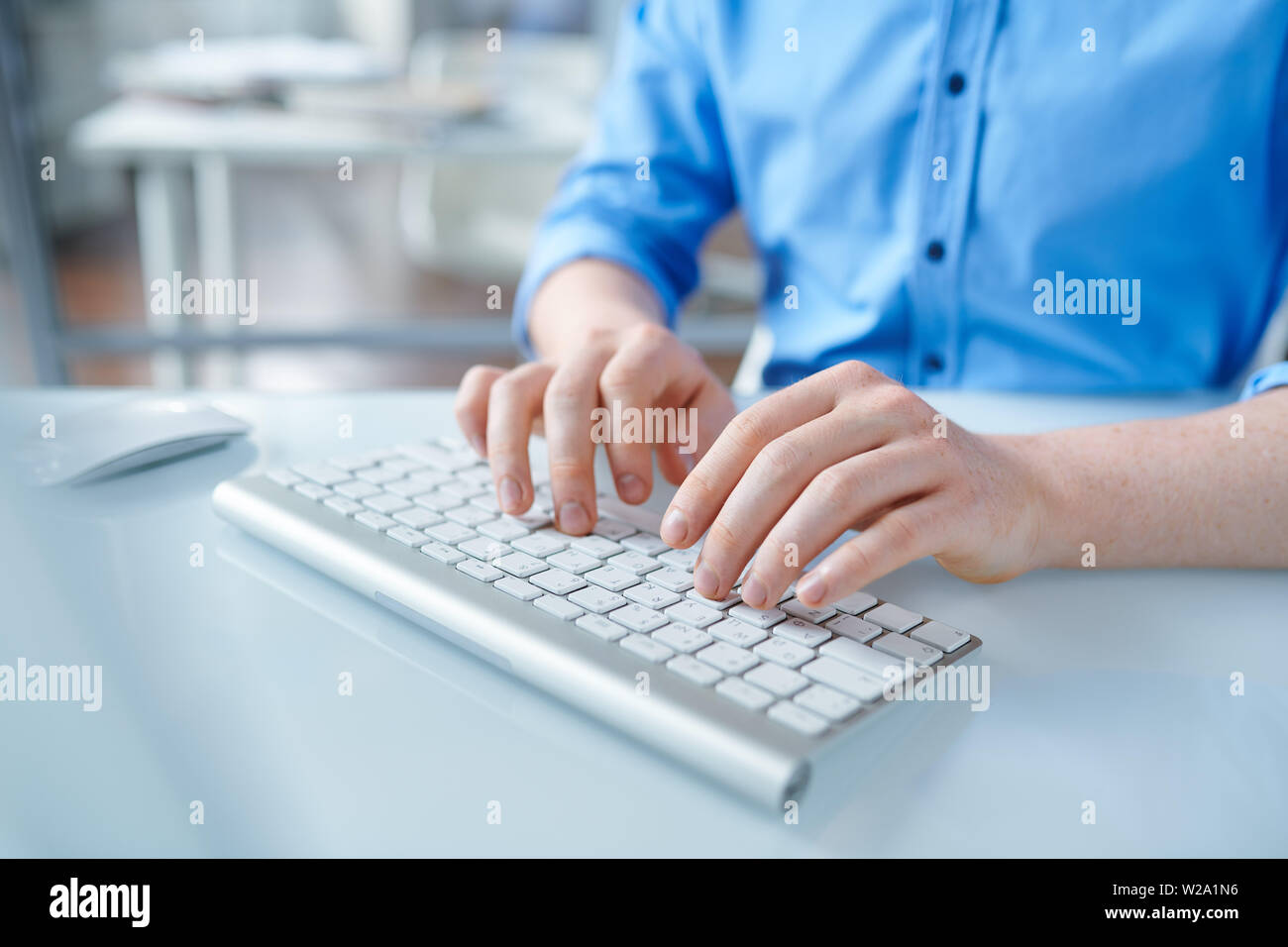 Creative designer in blue shirt touching buttons of computer keypad Stock Photo - Alamy
