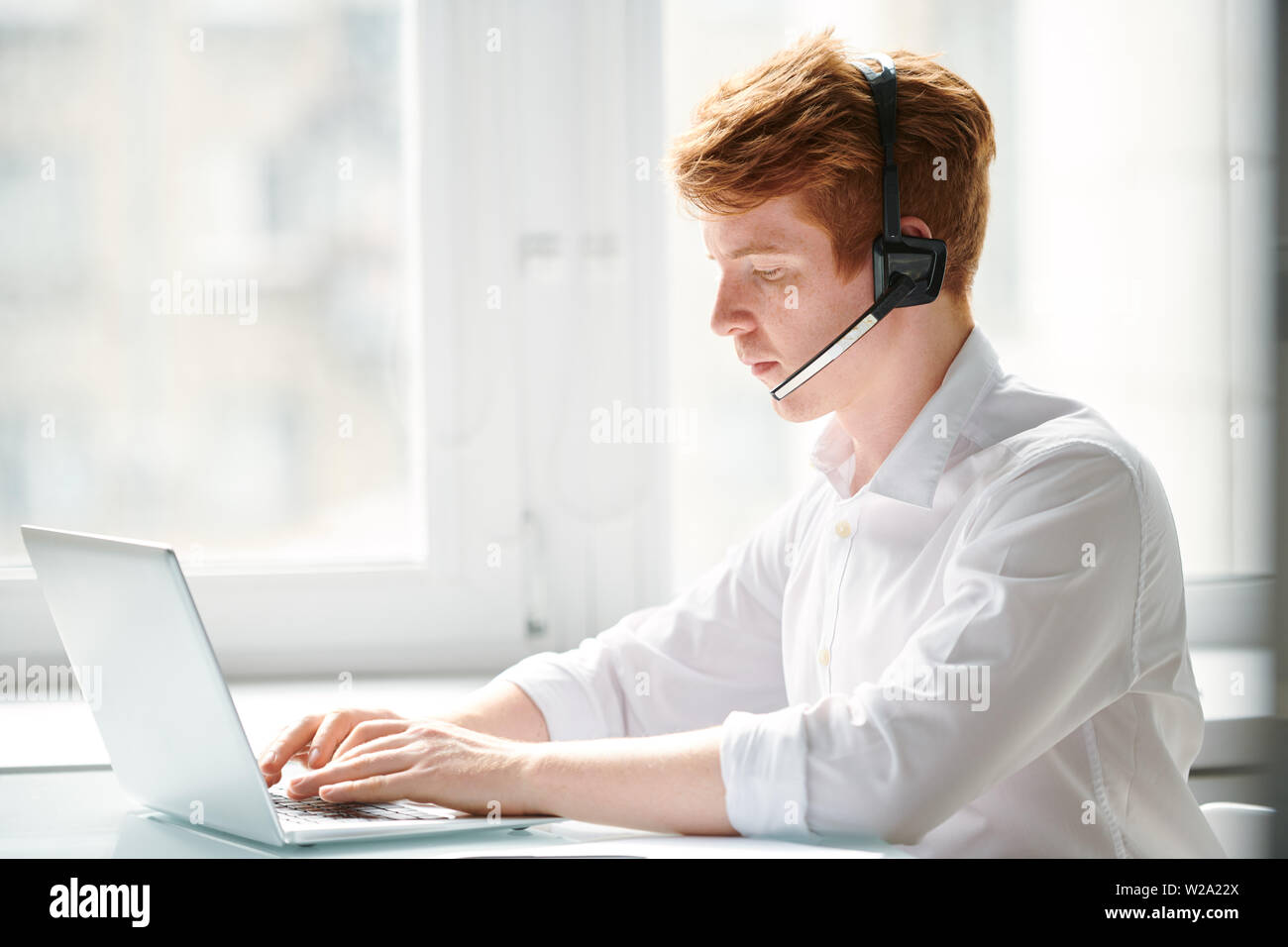 Young operator of call center communicating with online clients Stock ...