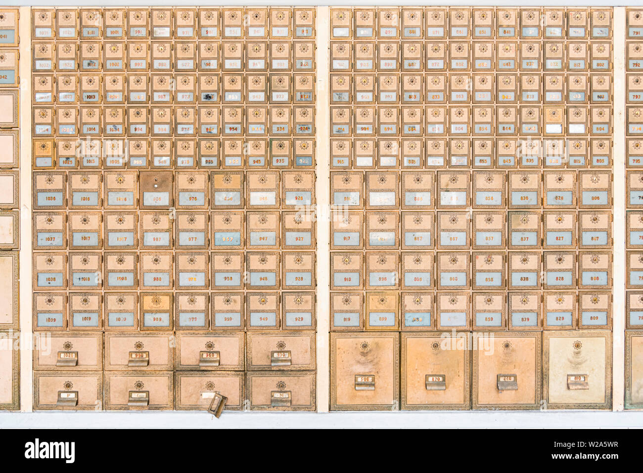 Rows of mid-century modern design post office mailboxes in brass metal ...