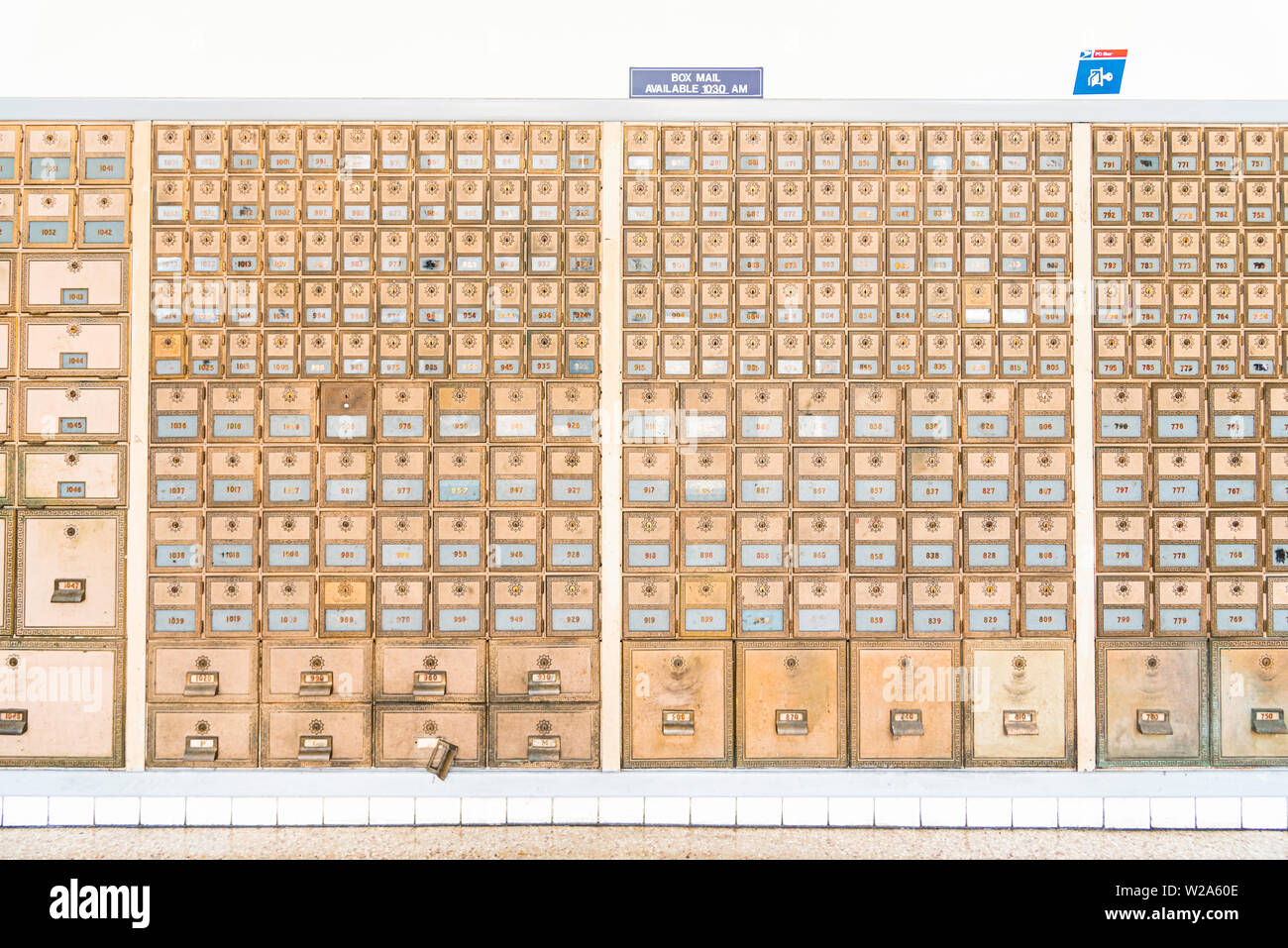 Rows of mid-century modern design post office mailboxes in brass metal ...