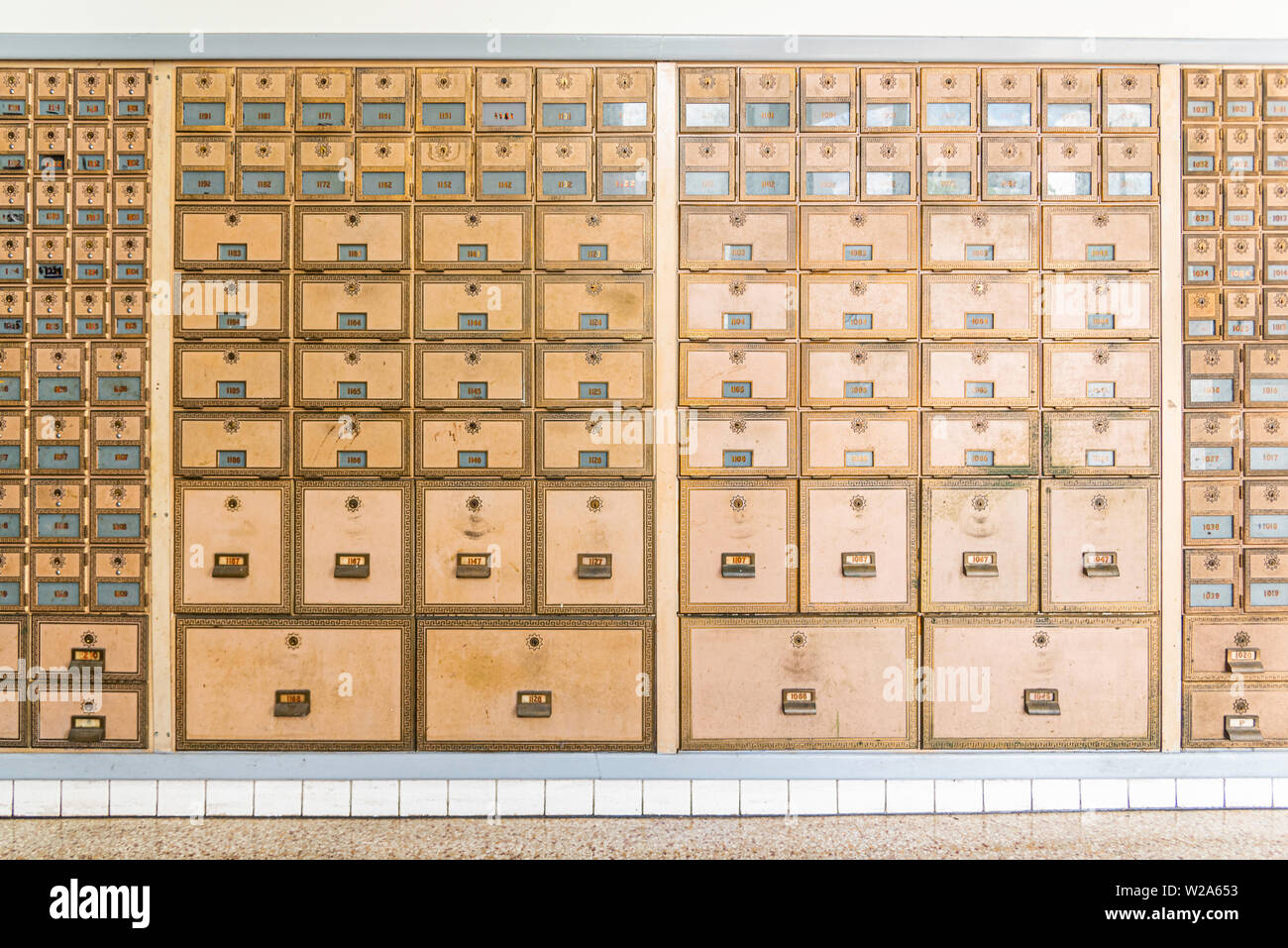 Rows of mid-century modern design post office mailboxes in brass metal ...