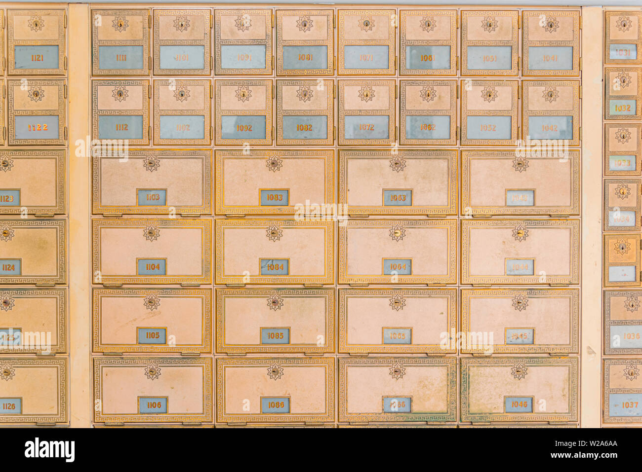 Rows of mid-century modern design post office mailboxes in brass metal ...