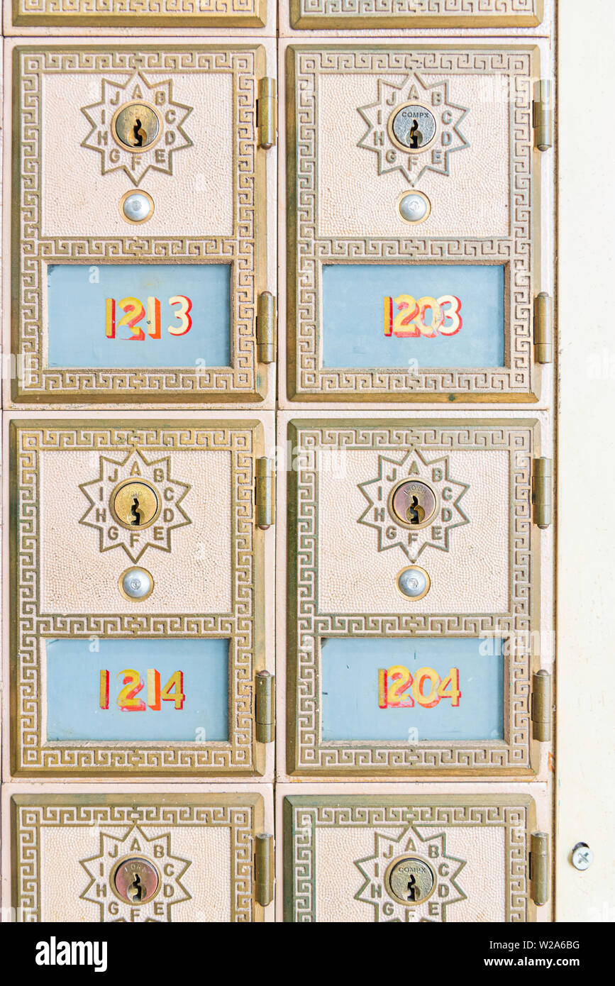 Rows of mid-century modern design post office mailboxes in brass metal ...