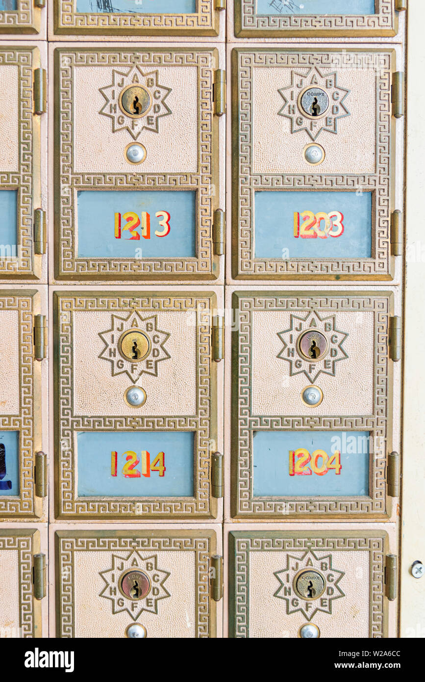 Rows of mid-century modern design post office mailboxes in brass metal ...