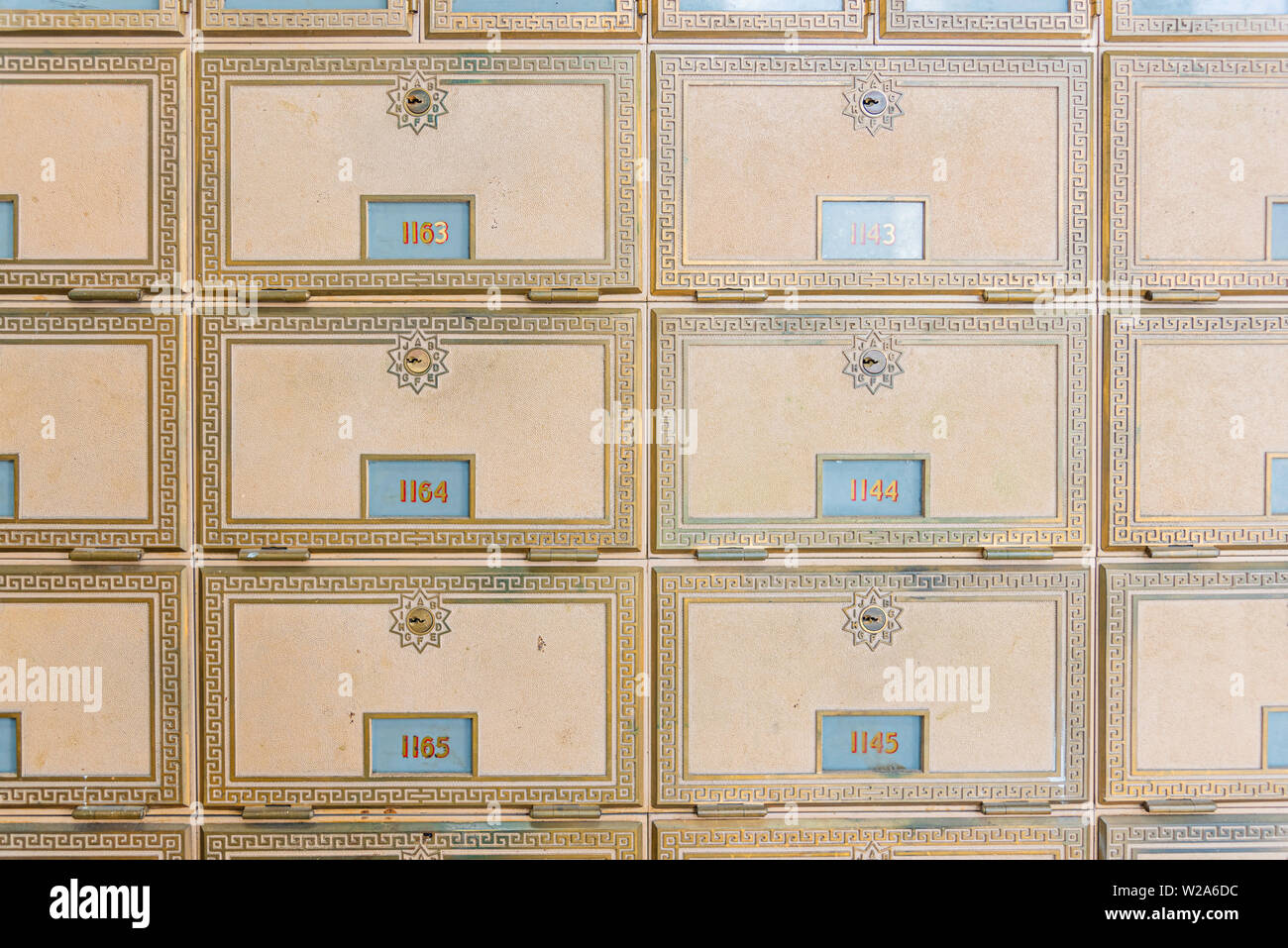 Rows of mid-century modern design post office mailboxes in brass metal ...