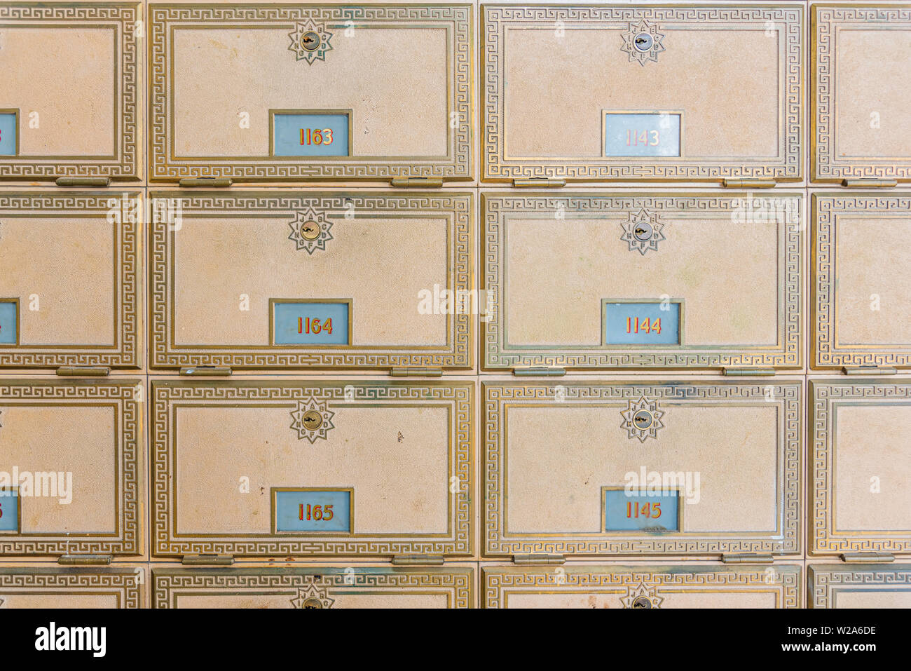Rows of mid-century modern design post office mailboxes in brass metal ...