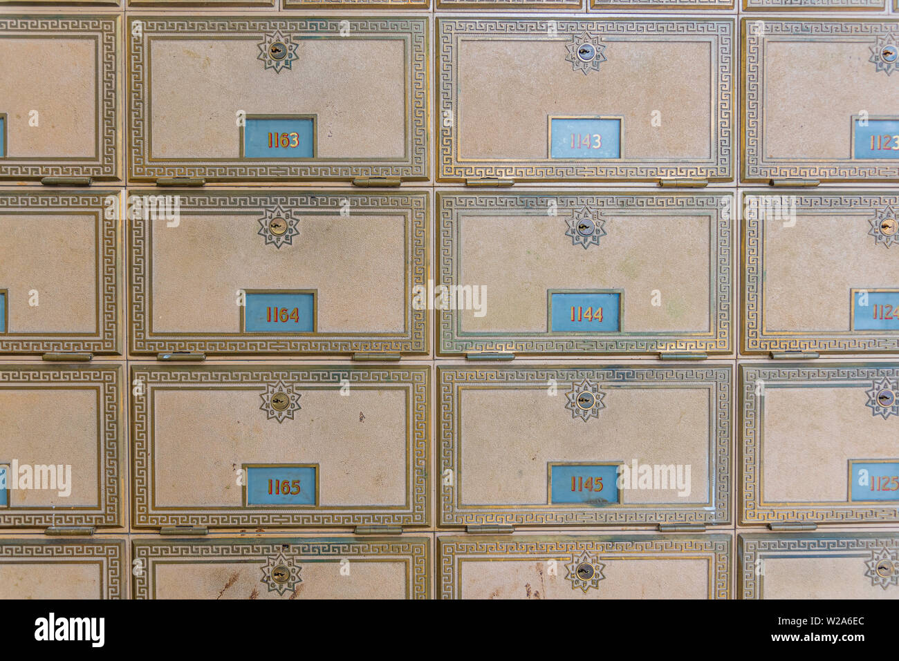 Rows of mid-century modern design post office mailboxes in brass metal ...