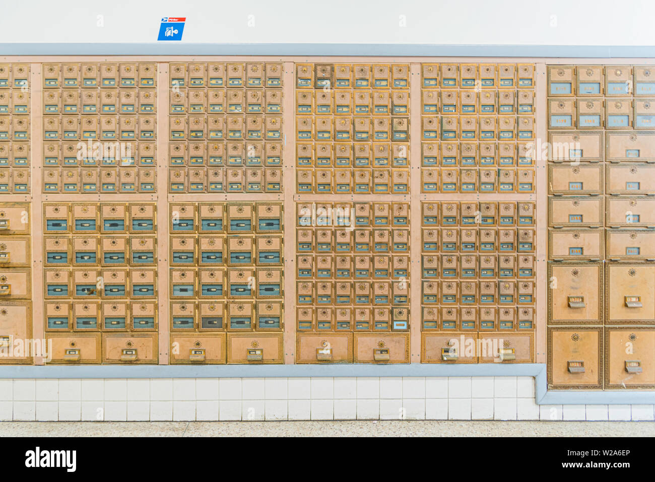 Rows of mid-century modern design post office mailboxes in brass metal ...