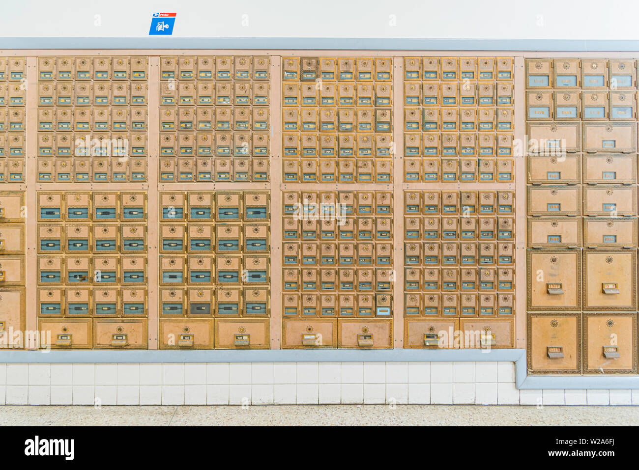 Rows of mid-century modern design post office mailboxes in brass metal ...