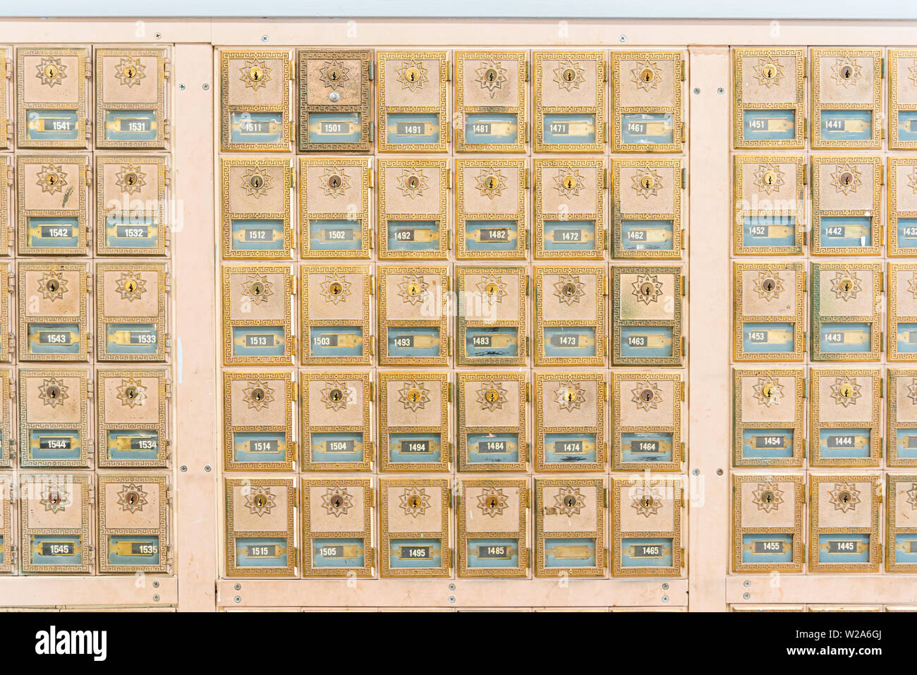 Rows of mid-century modern design post office mailboxes in brass metal ...