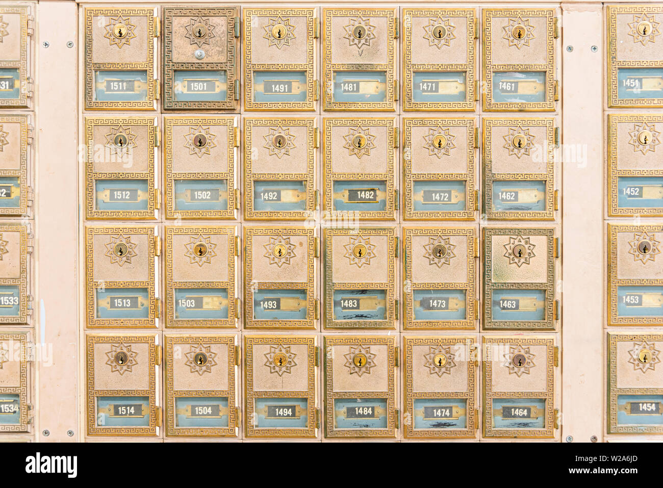 Rows of mid-century modern design post office mailboxes in brass metal ...