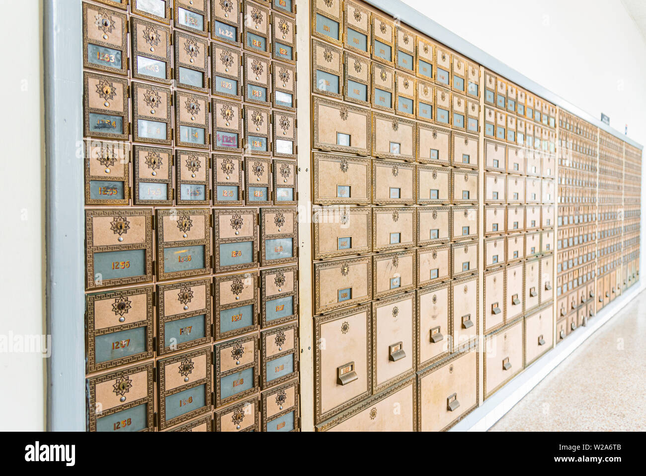 Rows of mid-century modern design post office mailboxes in brass metal ...