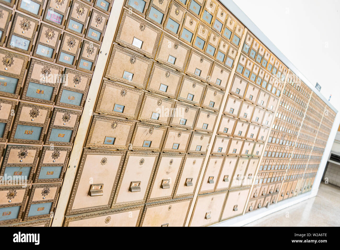 Rows of mid-century modern design post office mailboxes in brass metal ...
