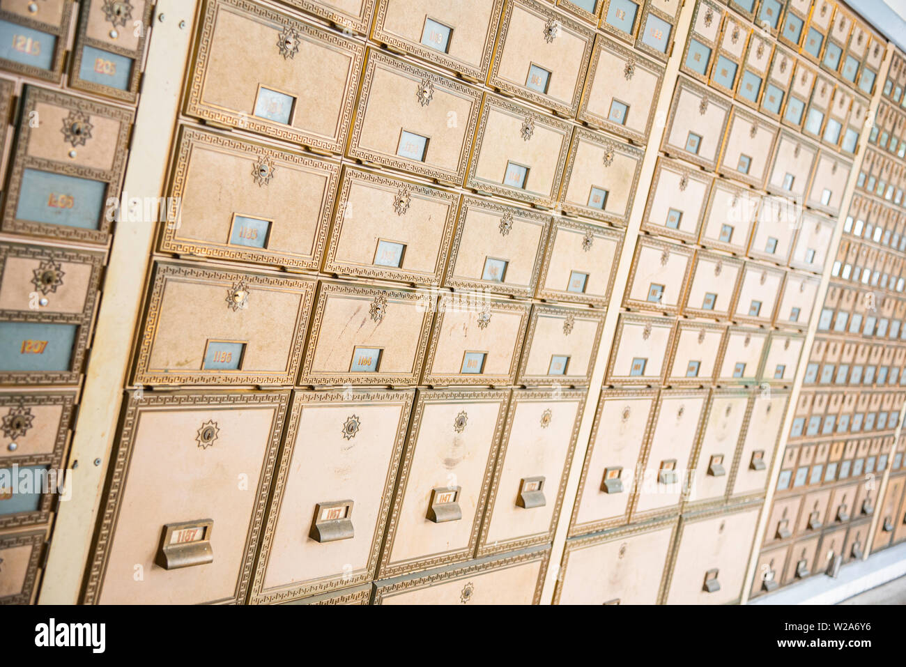 Rows of mid-century modern design post office mailboxes in brass metal ...