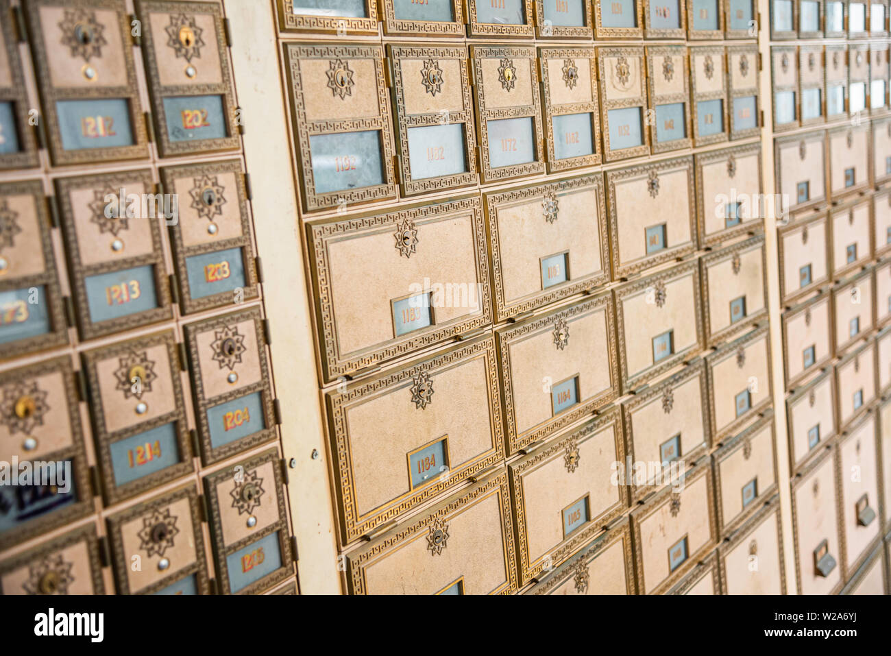 Rows of mid-century modern design post office mailboxes in brass metal ...