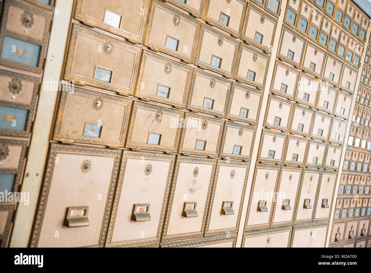 Rows of mid-century modern design post office mailboxes in brass metal ...