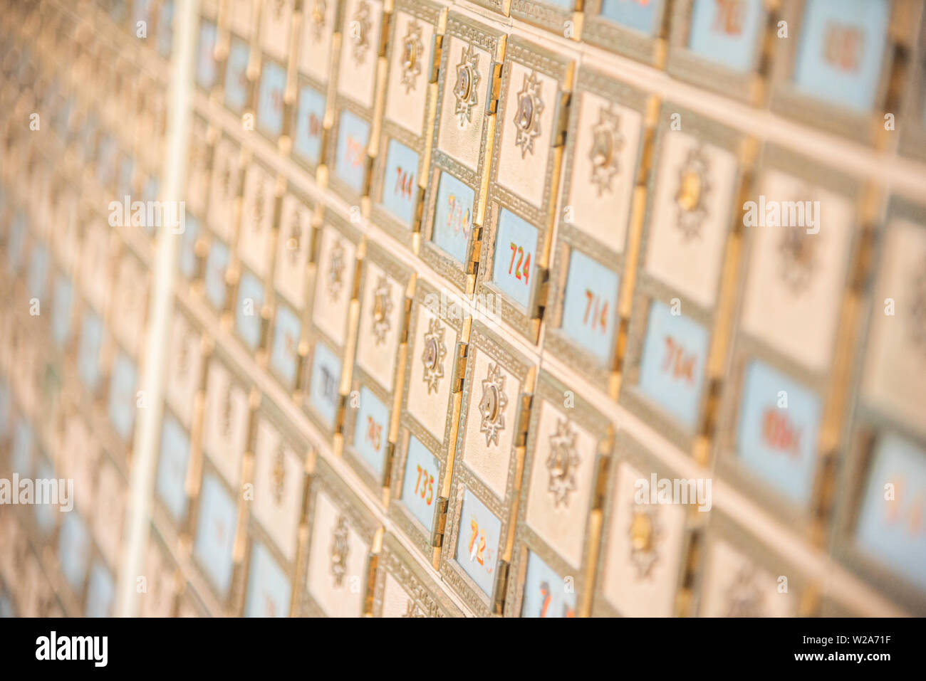 Rows of mid-century modern design post office mailboxes in brass metal ...
