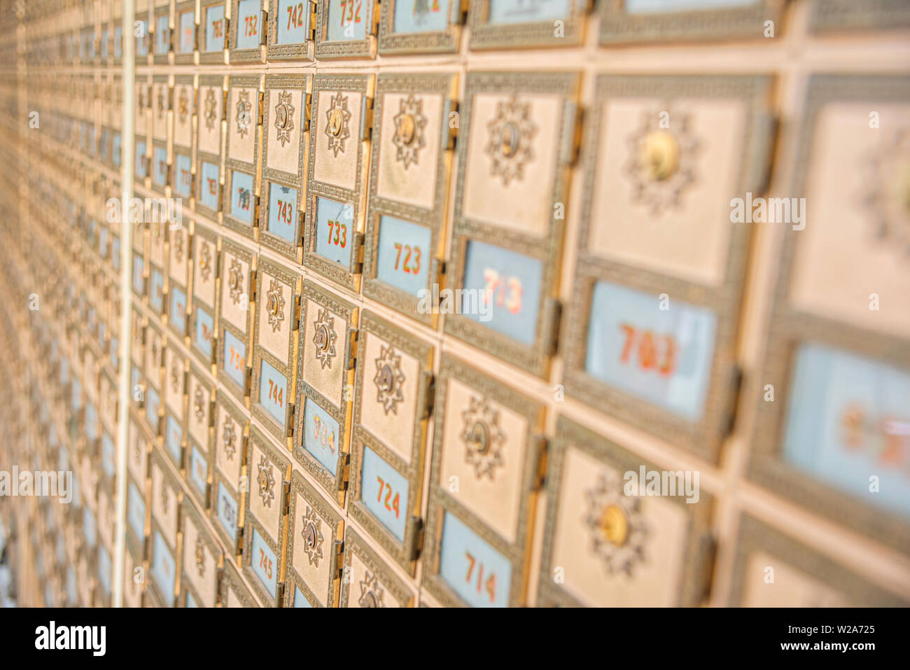 Rows of mid-century modern design post office mailboxes in brass metal ...