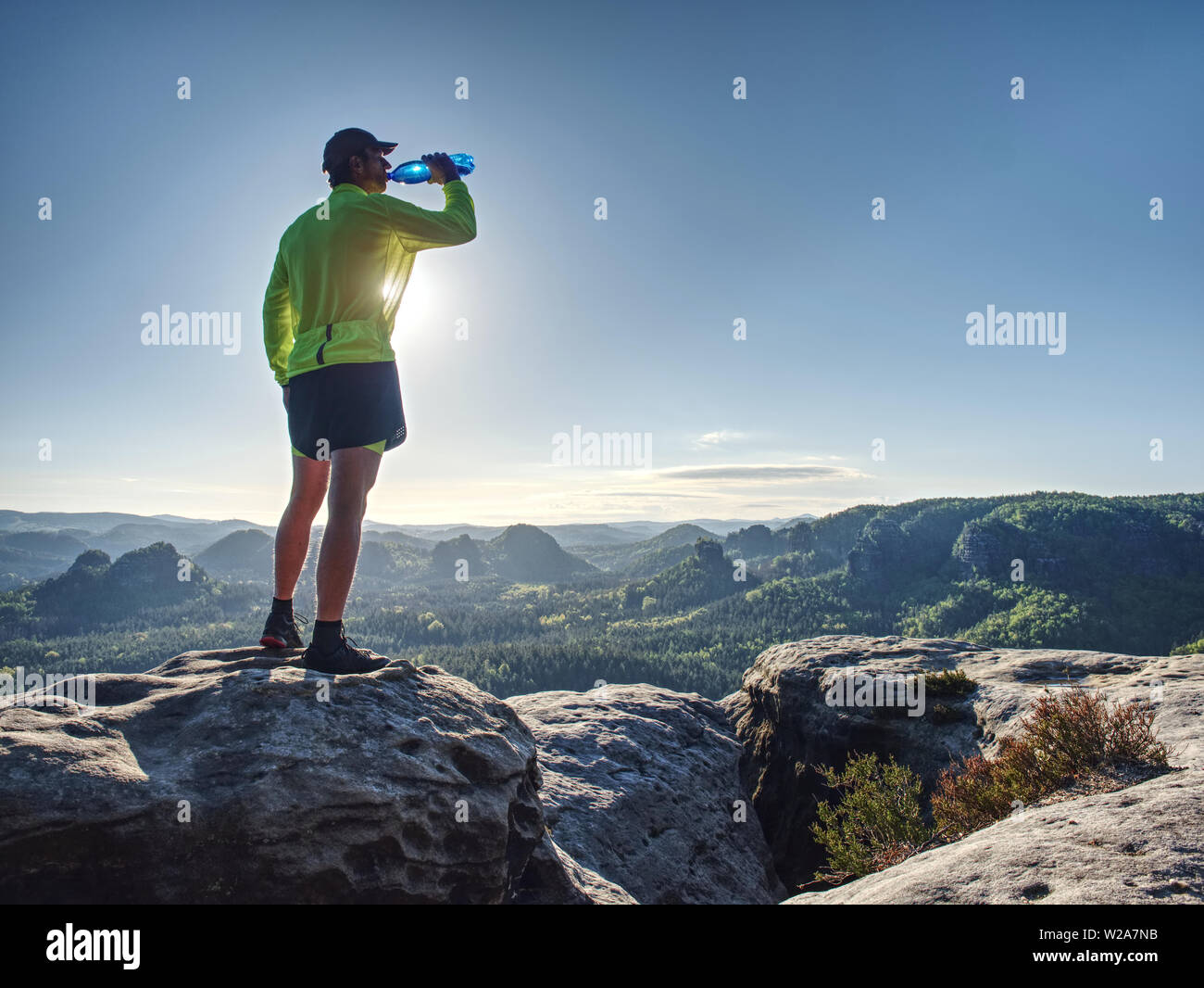 Fit runner in sport suit drinking the water from sport bottle with ...