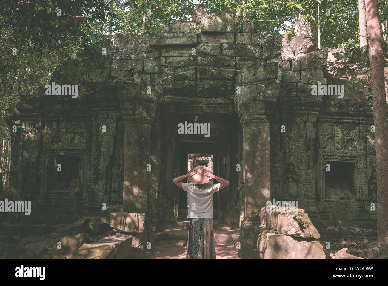 One tourist visiting Angkor ruins amid jungle, Angkor Wat temple ...