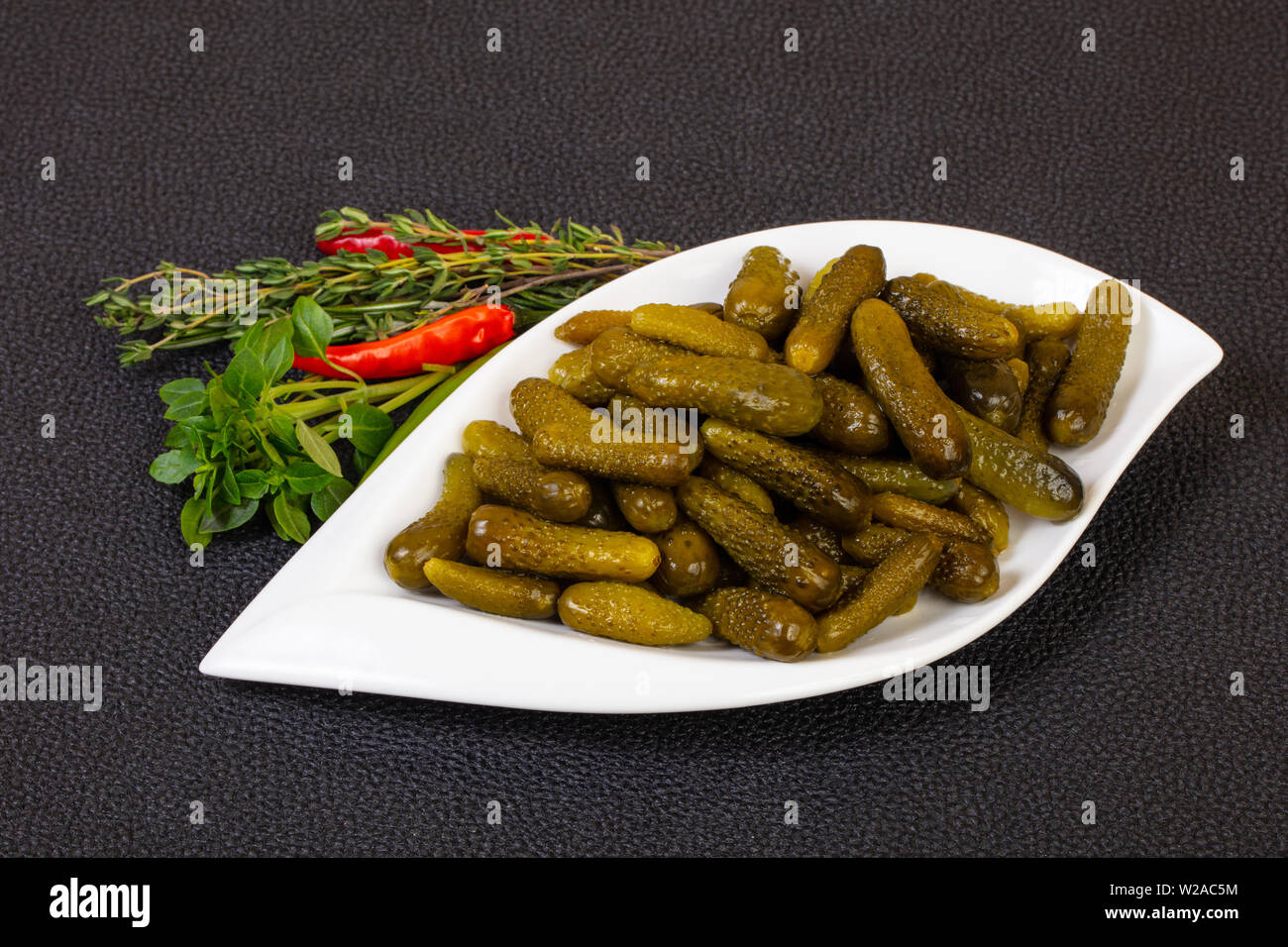 Pickled small cucumbers in the bowl served herbs Stock Photo - Alamy